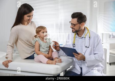 Mother and her cute baby having appointment with pediatrician in clinic ...