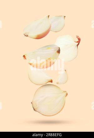 Cut fresh onions falling on light grey background Stock Photo - Alamy