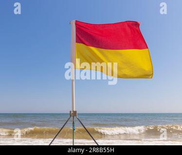 Swimming safety lifeguard flag erected by the RNLI on the beach in ...