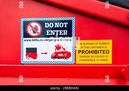 Hazard warning stickers on a red metal recycling skip Stock Photo - Alamy