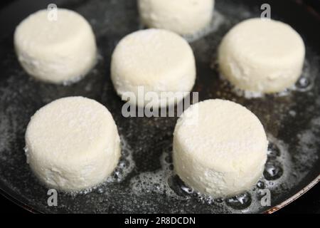 Uncooked cottage cheese pancakes in frying pan, closeup Stock Photo - Alamy