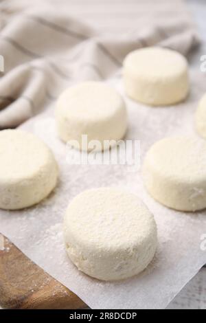 Board with uncooked cottage cheese pancakes and ingredients on wooden ...