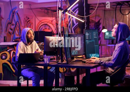 African american internet thief planning phishing attack and online scam in hideout workspace ...