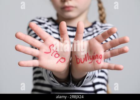 Girl showing hands with phrase Stop Bullying on light grey background ...