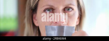 Beautiful woman with duct tape on mouth closeup Stock Photo - Alamy