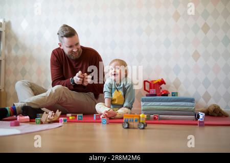 Father playing with baby with down syndrome Stock Photo - Alamy