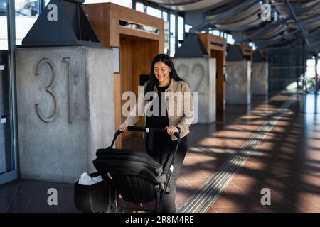 View of woman pushing pram at train station Stock Photo - Alamy