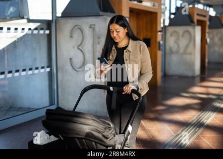 View of woman pushing pram at train station Stock Photo - Alamy