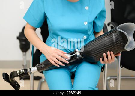 Female technician holding prosthetic limb checking in medical clinic ...