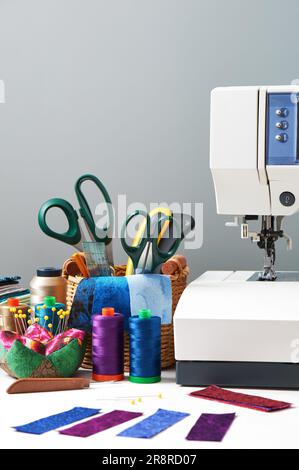 Sewing accessories in a basket and spools of threads next to sewing ...