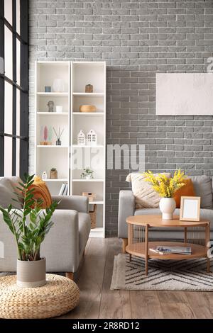 Shelving unit with vase, frame and pillows near light curtain in room ...