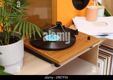 Stylish turntable with vinyl record console table in room Stock Photo ...