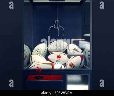 A concept 3D render of a arcade claw grab game filled with rugby balls ...