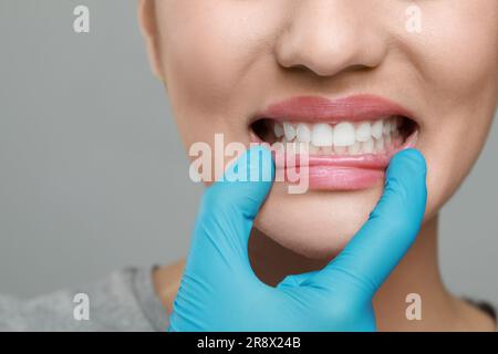 Doctor examining woman's gums on white background, closeup Stock Photo ...