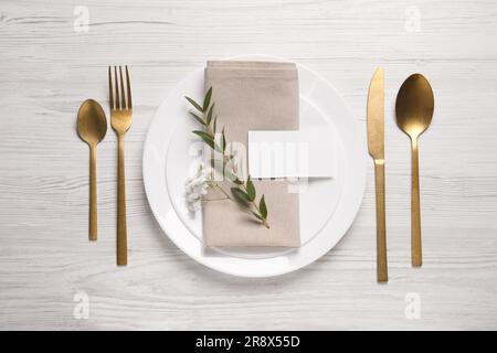 Stylish table setting with blank card and floral decor on white ...