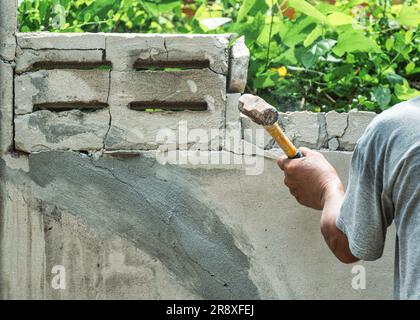 Hand of worker using hammer smashing and demolish on brick block wall ...