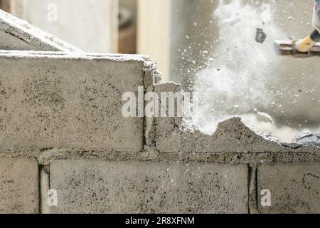 Hand of worker using hammer smashing and demolish on brick block wall ...