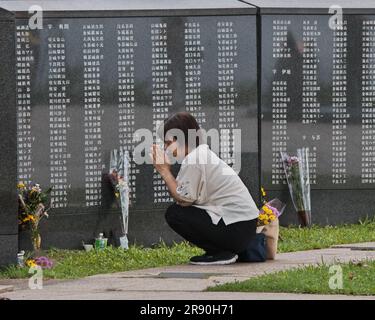 A bereaved family prays for victims at the Peace Memorial Park in ...