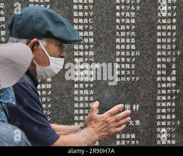 A bereaved family prays for victims at the Peace Memorial Park in ...