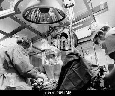 Hip replacement surgery. Surgeons performing a hip replacement ...