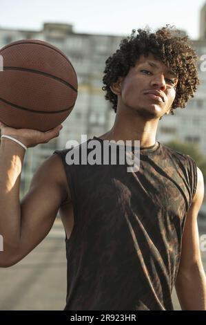 Confident athlete with curly hair playing basketball Stock Photo - Alamy
