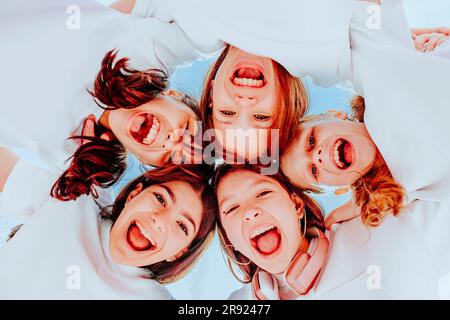 Happy teenage friends screaming and huddling with arms around Stock ...