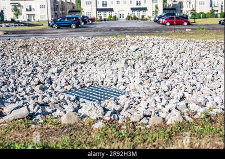 Grated storm drain inlet surrounded by rock for soil erosion control ...