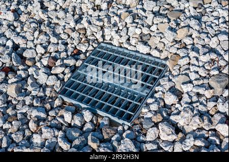 Grated storm drain inlet surrounded by rock for soil erosion control ...