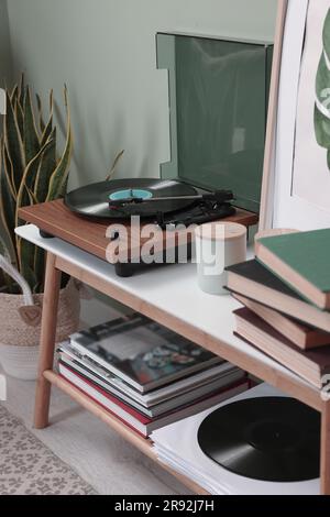 Stylish turntable with vinyl record console table in room Stock Photo ...
