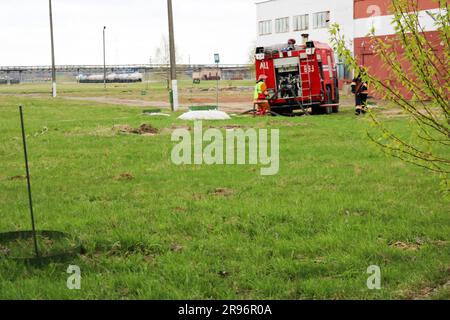 A large red fire rescue vehicle, a truck to extinguish a fire and male ...