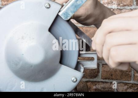 Knife sharpener in the form of a circle and a hand with a blade on the ...