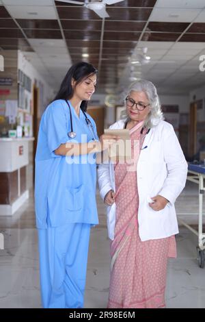Doctors discussing patient case status with his medical staff after ...