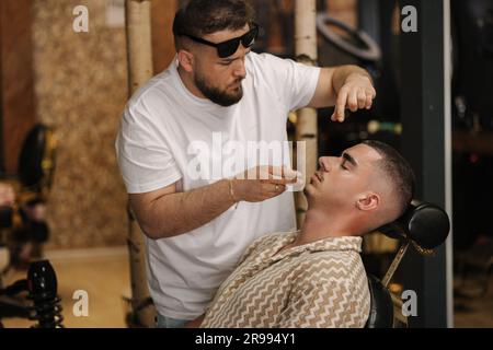 Side view process of threading procedure in barber shop. Professional ...