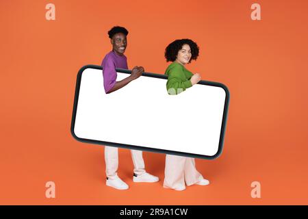Smiling casual young male and female customers picking fresh fruits and ...