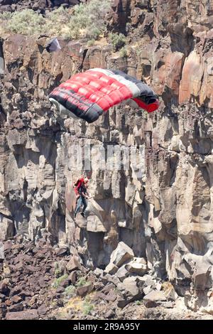 Tandem base jumpers soaring down the canyon after jumping off the ...