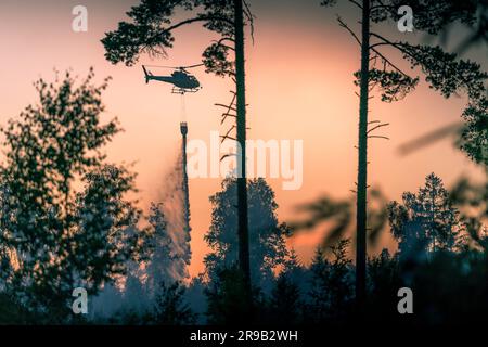 Broby, Sweden, 25 June, 2023 Helicopters water bombing a wildfire in ...