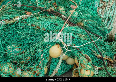 Messy green fishing net by a harbor Stock Photo - Alamy