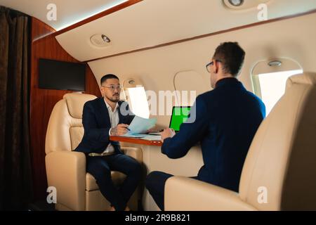 Two Businessman CEO couple in eyeglasses sitting inside a private jet ...