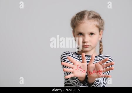 Girl showing hands with phrase Stop Bullying on light grey background ...