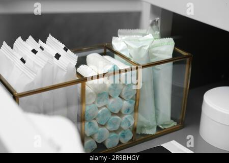 Organizer with different feminine hygiene products on toilet bowl in ...