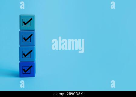 Cubes with check marks on light blue background, top view. Space for ...