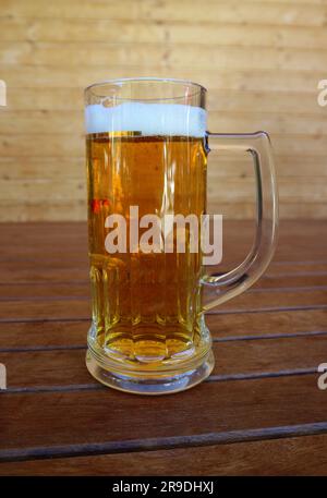 Closeup a glass of mouthwatering chilled beer being served on the table ...
