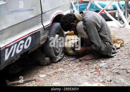 A Pakistani drug addict smokes heroin on the side of the road in ...