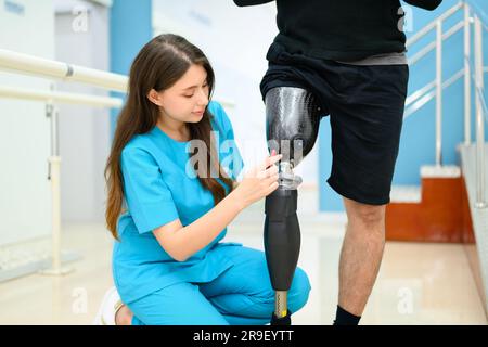 Physiotherapist adjusting prosthetic leg of patient in hospital Stock ...