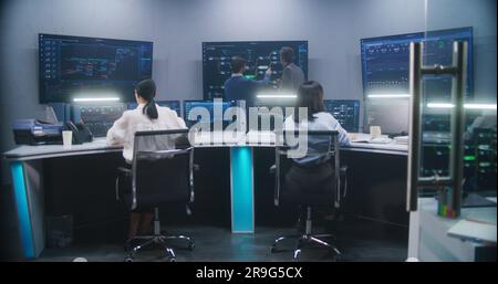 Female software engineer sits at computer with displayed blockchain ...