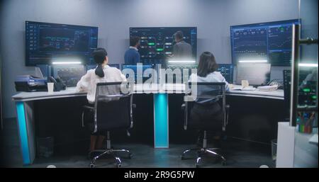 Female software engineer sits at computer with displayed blockchain ...
