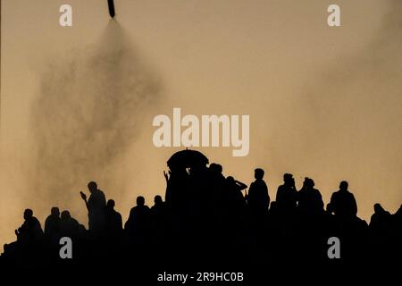 Water mist is sprayed on Muslim pilgrims as they walk towards the rocky ...