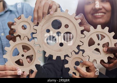 Office worker holding cog wheel as unity and teamwork in corporate ...