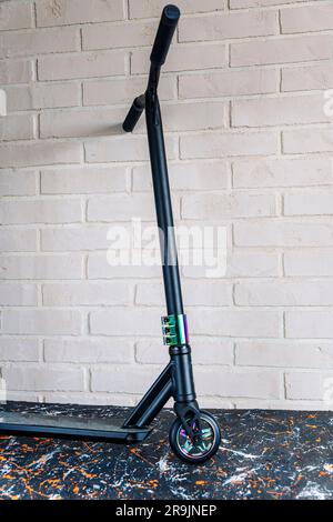 The front wheel of a rainbow-colored stunt scooter or a durable ...