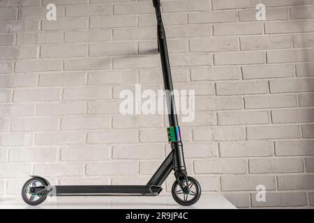 Side view of a stunt scooter with rainbow-colored wheels against a ...